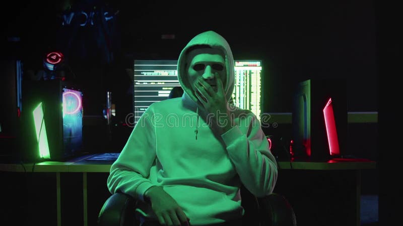 Portrait of a Mysterious Hacker in a Hood, Sitting at a Table and ...