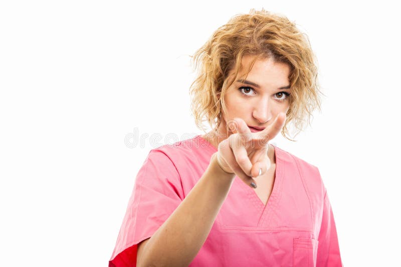 Portrait Of Nurse Wearing Pink Scrub Showing Watching You Gesture Stock