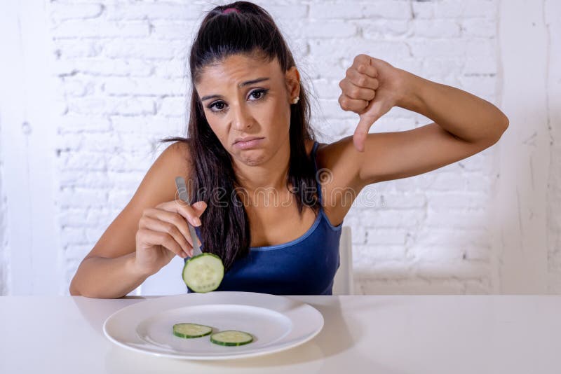 Depressed Dieting Woman Holding Folk Looking At Small Green Vegetable