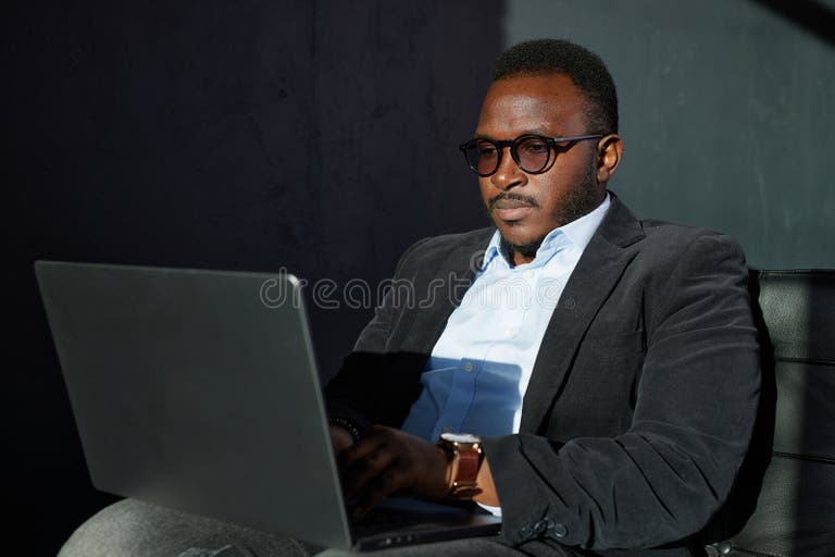 Portrait of Pensive African Business Man in Glasses Sitting at Desk ... Portrait of Pensive African Business Man in Glasses Sitting at Desk ...