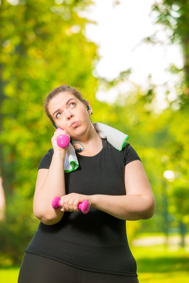 Portrait of a Pensive Plus Size Model Engaged with Dumbbells during a ...
