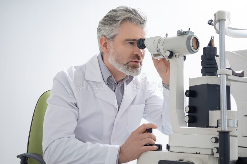 Portrait Picture of a Male Doctor Looking into Microscope and Looking ...