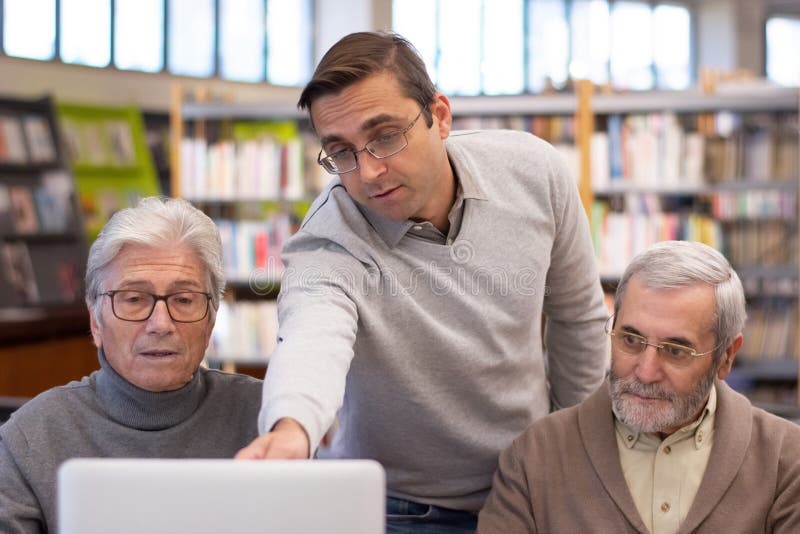 Portrait of Positive Elderly Men with Teacher in Library Stock Photo ...