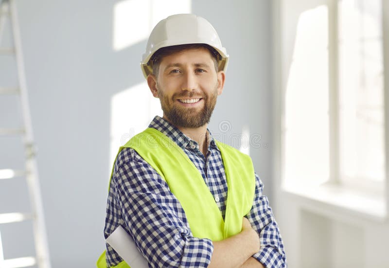 Portrait of Positive, Handsome Young Male Construction Worker in Hard Hat, Smiling at the Camera ...