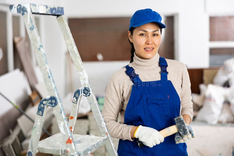 Portrait of a Positive Woman Builder with a Hammer in Hands Stock Photo ...