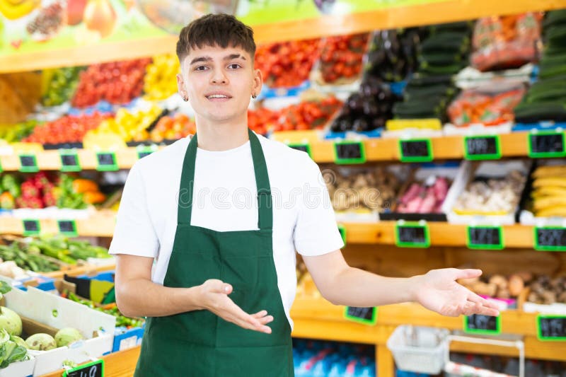 Portrait of Positive Young Salesman in the Vegetable Section of Grocery ...
