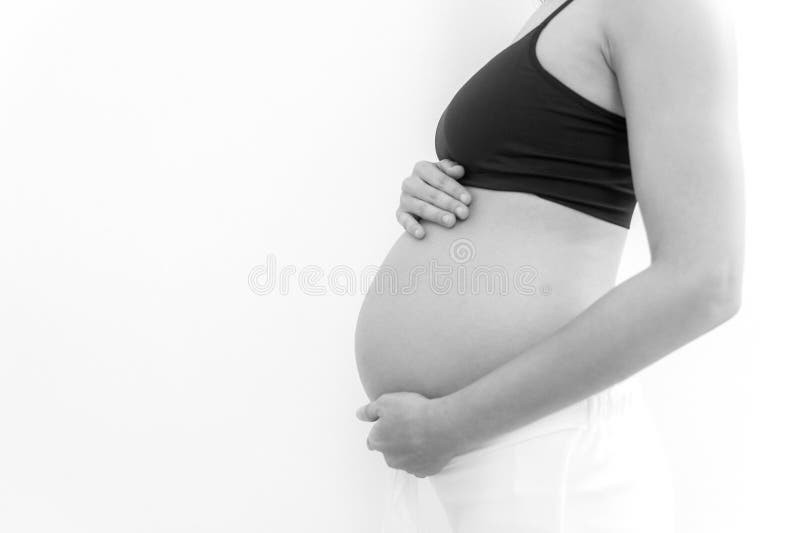 Portrait Of Pregnant Woman Standing Near Window With White Background