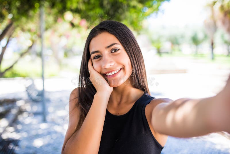 Portrait Of Pretty Young Latin Girl Taking Selfies With Her Smart Phone