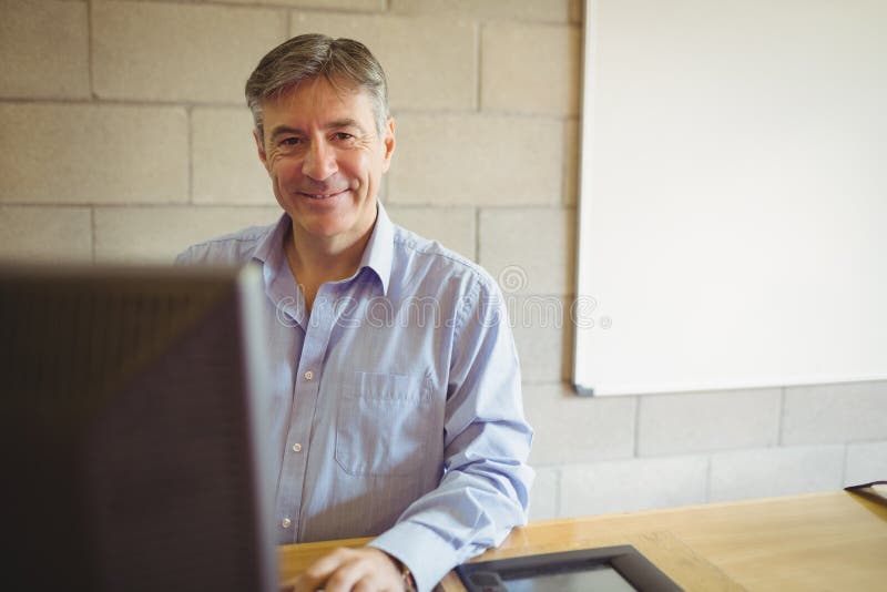 Professor Sitting at Desk Using Digital Tablet Stock Image - Image of ...