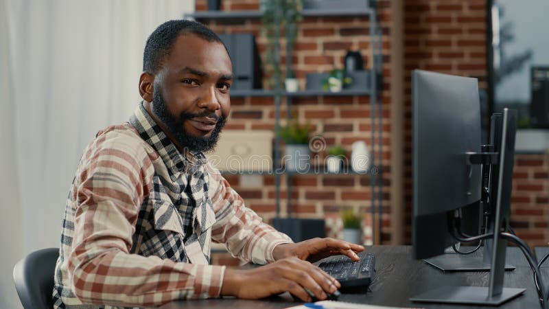 Portrait Of Programer Typing Programming Code On Computer Keyboard Turning Head And Smiling