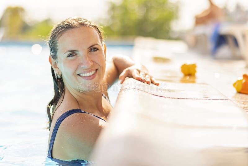 Portrait Of Relaxed Attractive Tanned Woman Lean On Swimming Pool