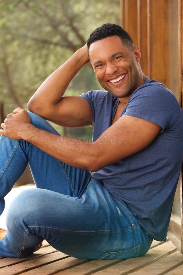 Relaxed Young Black Man Sitting Outside and Smiling Stock Image - Image ...