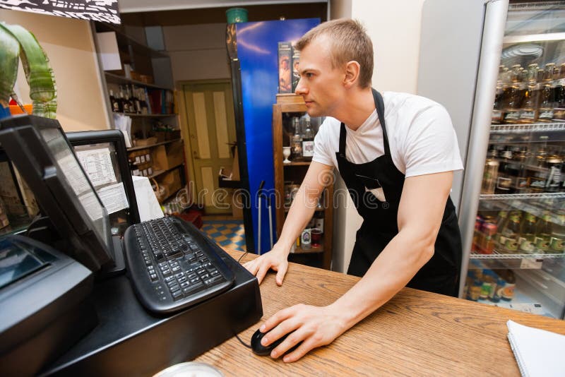 Portrait of Salesman Using Computer at Cash Counter in Supermarket ...