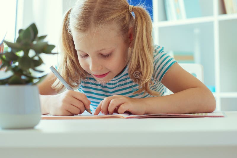 Portrait of Schoolgirl at Classroom Writing at the Table Stock Photo ...