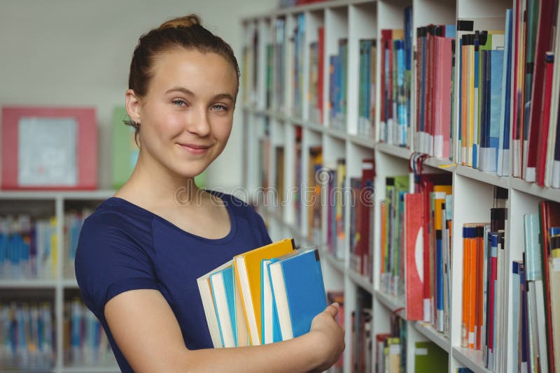 Portrait of Schoolgirl Standing with Stack of Books in Library Stock ...