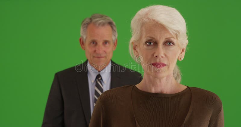 Portrait Of Senior Businesswoman Standing Looking At Camera On Green