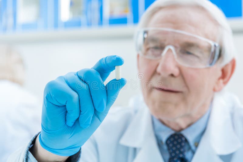 Portrait of Senior Man Scientist Analyzing Pill in Hand Stock Image ...