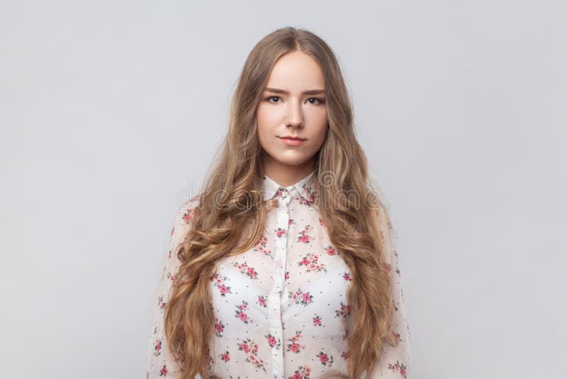 Serious Assertive Woman With Wavy Blond Hair Standing And Looking At