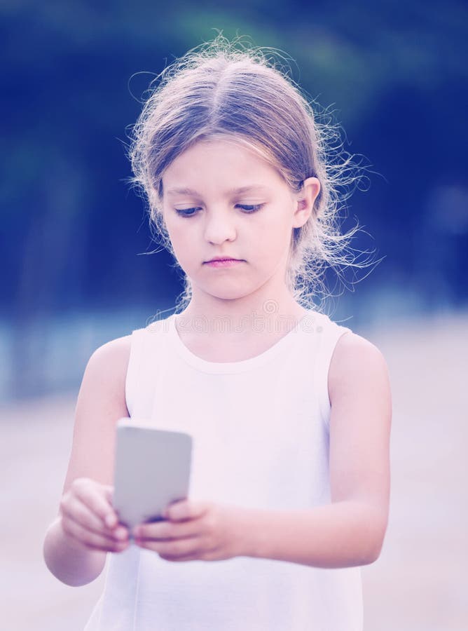 Portrait of Serious Girl Looking at Mobile Phone Stock Photo - Image of ...