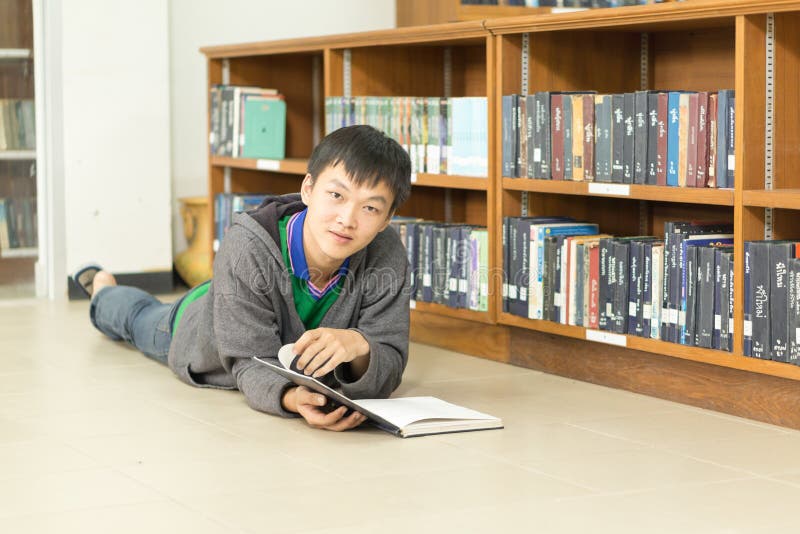 Portrait Of A Serious Young Student Reading A Book In A Library Stock ...