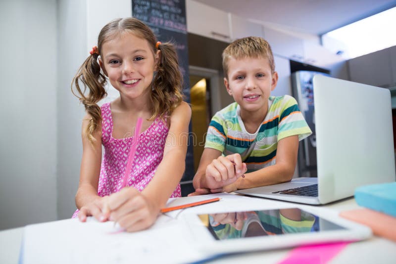 Portrait of Siblings Doing Their Homework in Kitchen Stock Photo ...