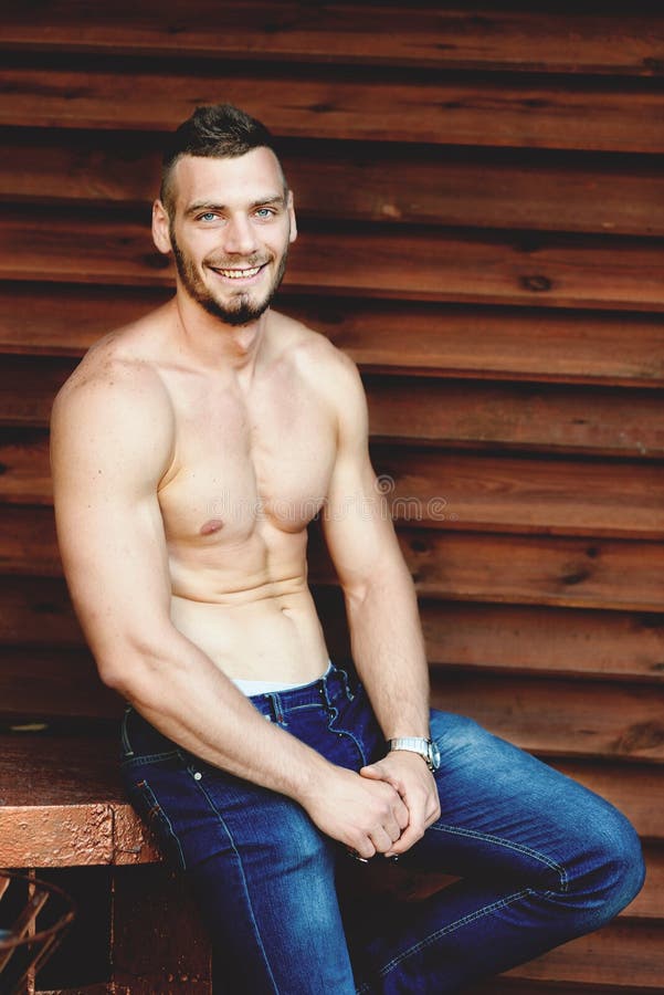 Athletic Man in White T-shirt Tight Abs Sitting on a Leather Sofa Stock ...