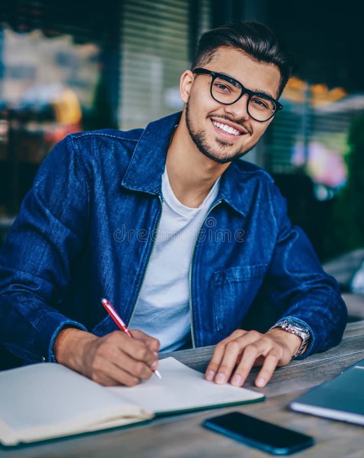 Portrait of Skilled Caucasian Male Student Writing in Notepad Enjoying ...