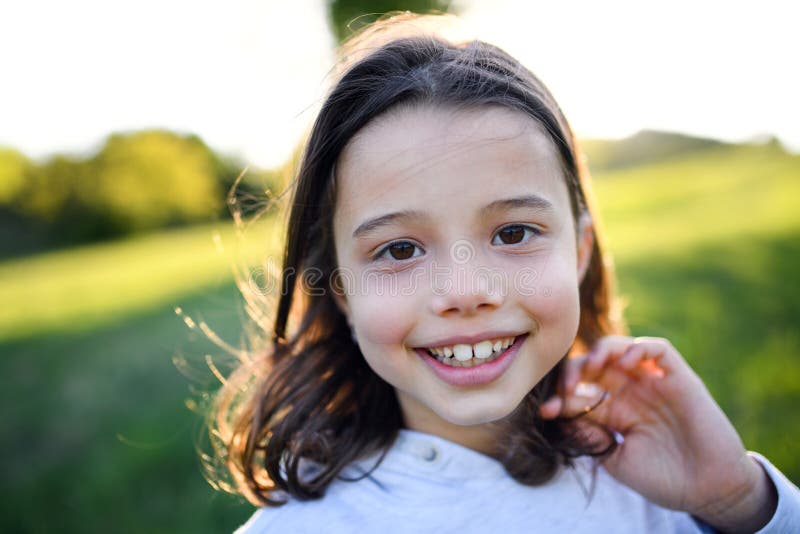 Portrait of Small Girl Standing Outdoors in Spring Nature, Looking at ...