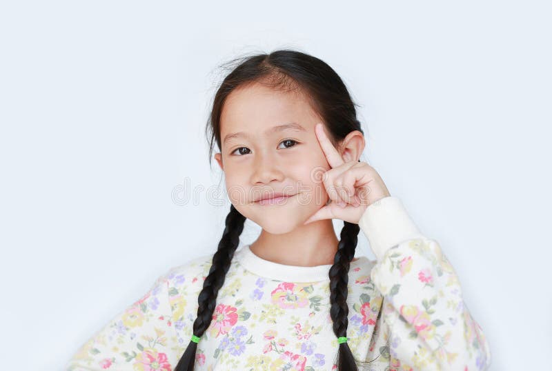 Portrait Smiling Asian Little Girl Pointing Index Finger To Head for ... Portrait Smiling Asian Little Girl Pointing Index Finger To Head for ...