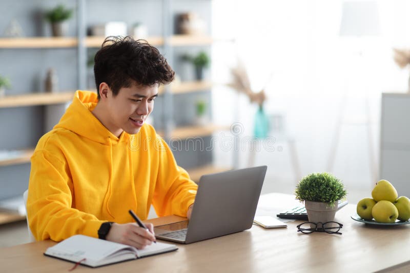 Smiling Asian Man Working on Laptop and Writing Stock Photo - Image of ...