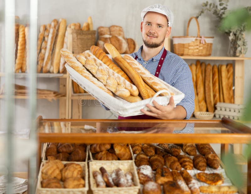 Portrait of Smiling Baker with Fresh Bread and Baguettes at Bakery ...