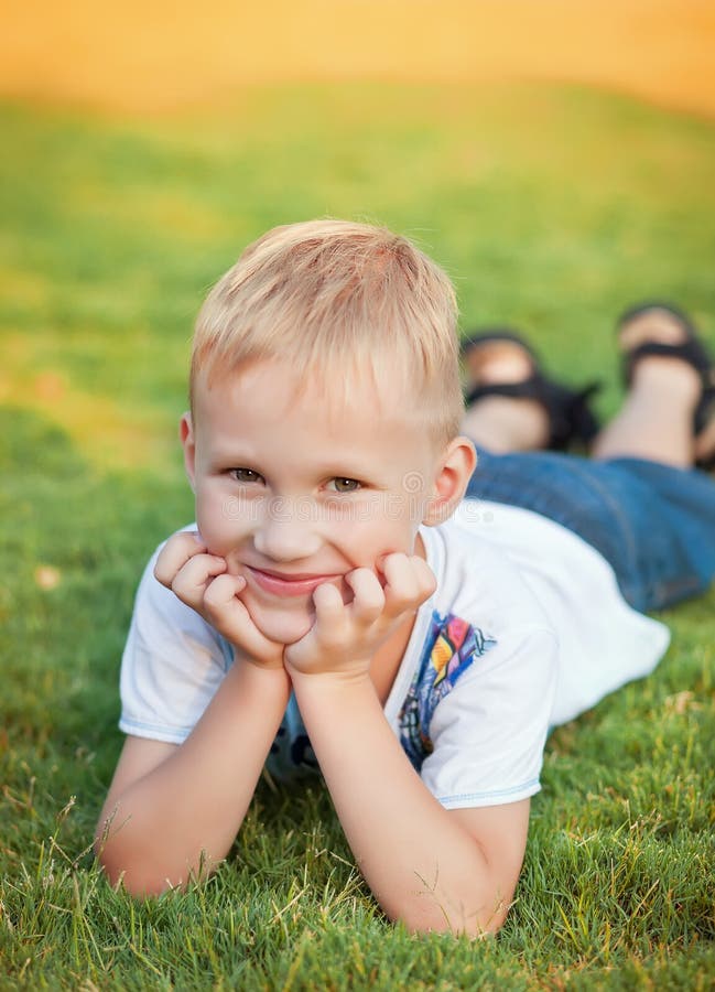 Portrait of a Smiling Boy Lying on Green Grass Stock Photo - Image of ...