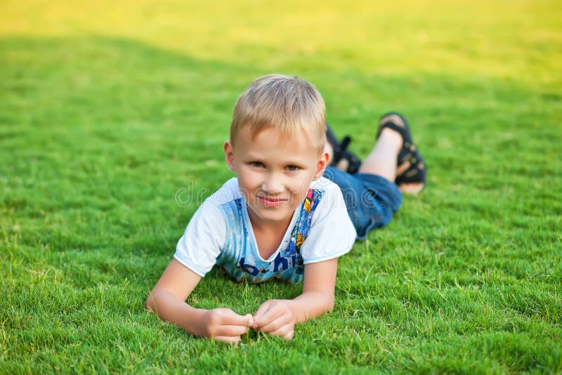 Portrait of a Smiling Boy Lying on Green Grass Stock Photo - Image of ...