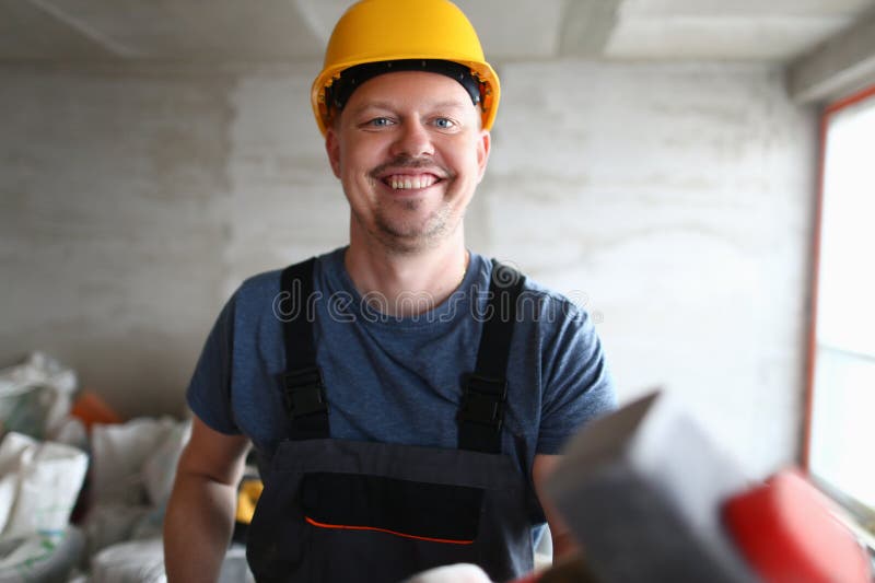 Portrait of Smiling Builder at Construction Site with Sledgehammer in ...