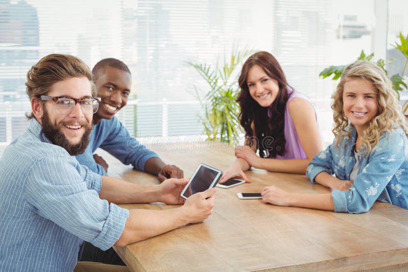 Portrait of Smiling Business Professionals Using Technology at Desk ...