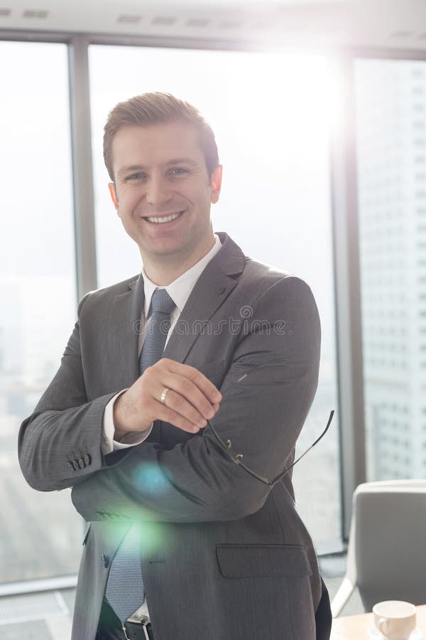 Portrait of Smiling Businessman Standing with Eyeglasses at Office ... Portrait of Smiling Businessman Standing with Eyeglasses at Office ...