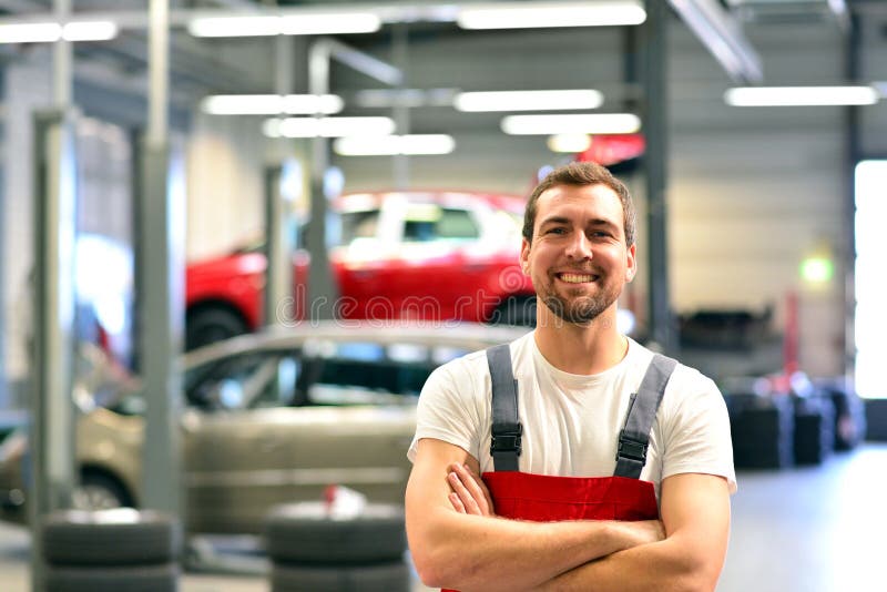 Portrait of a Smiling Car Mechanic in Car Workshop in Woking Clothes ...
