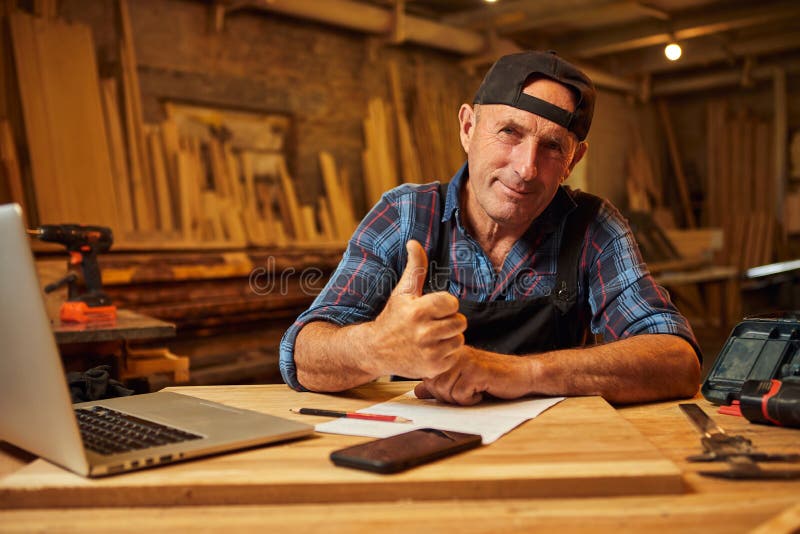 Portrait of Smiling Carpenter Works on the Computer and Raises a Finger ...