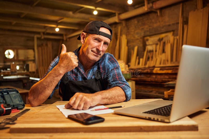 Portrait of Smiling Carpenter Works on the Computer and Raises a Finger ...