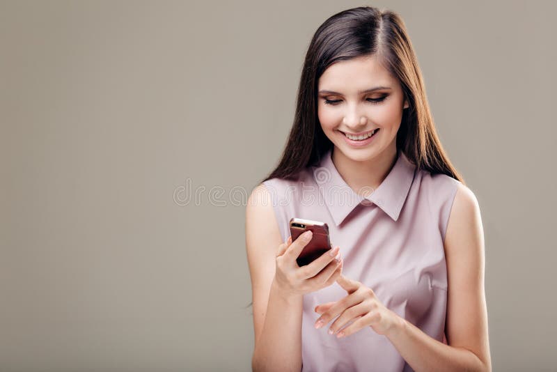 Portrait of a Smiling Casual Woman Holding Smartphone Over White ... Portrait of a Smiling Casual Woman Holding Smartphone Over White ...