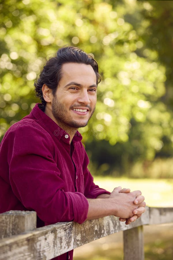 Portrait of Smiling Casually Dressed Mature Man Leaning on Fence on ... Portrait of Smiling Casually Dressed Mature Man Leaning on Fence on ...