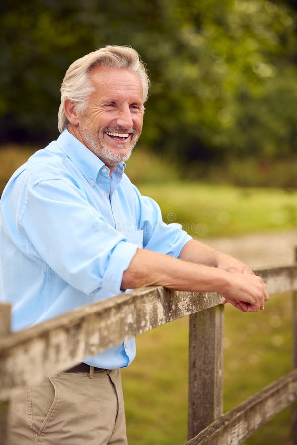 Portrait Of Smiling Casually Dressed Mature Or Senior Man Leaning On