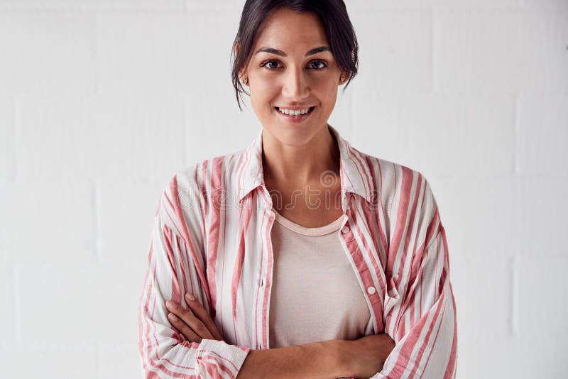 Portrait of Smiling Casually Dressed Woman Standing Against White Brick ... Portrait of Smiling Casually Dressed Woman Standing Against White Brick ...