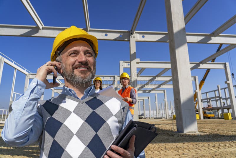 Portrait of Smiling Construction Foreman with Mobile Phone at Large ...