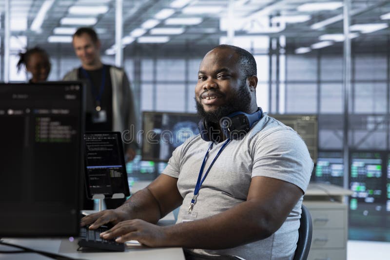 Portrait of Smiling Engineer in Data Center Optimizing it ...