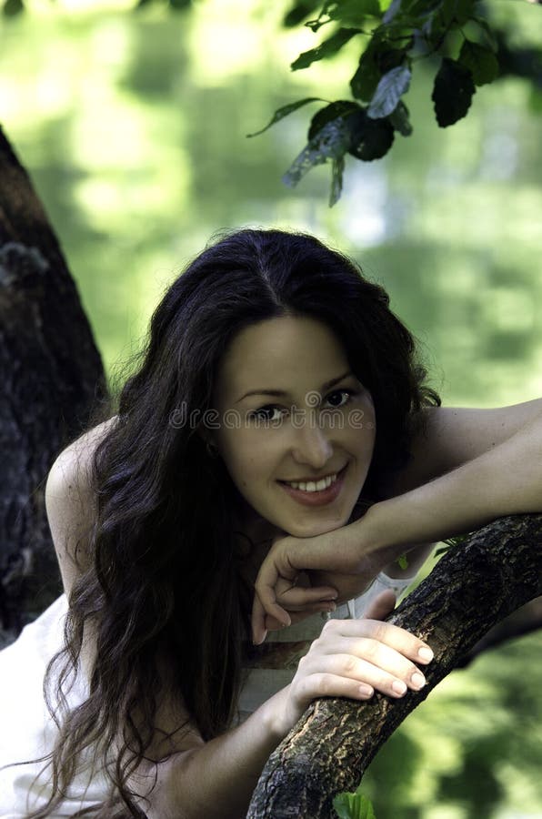 Portrait of a Smiling Girl Sitting on a Tree Stock Photo - Image of ...