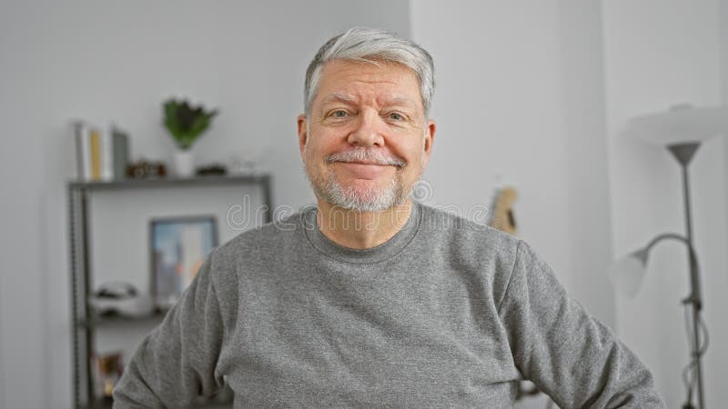 A Portrait of a Smiling, Grey-haired Man Posing in a Modern Living Room ...