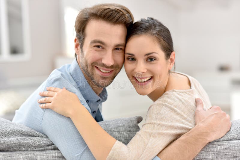 Portrait of Smiling Happy Couple Sitting on Sofa Stock Photo - Image of ...
