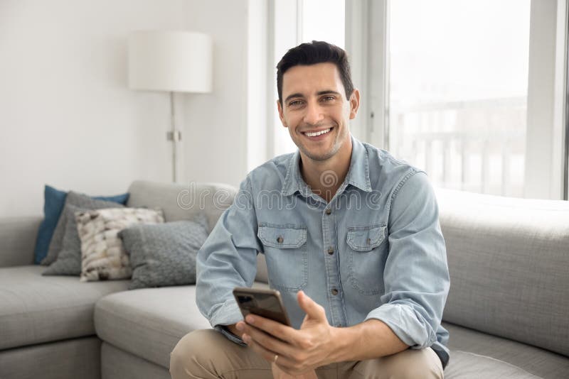 Portrait of Smiling Hispanic Enjoy Remote Communication on Smartphone ...