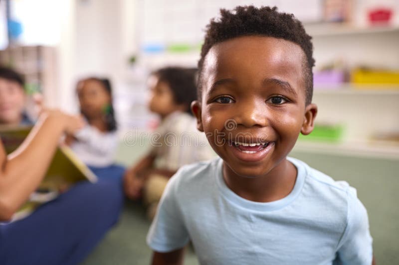 Portrait of Smiling Male Elementary School Pupil Sitting in Classroom ...